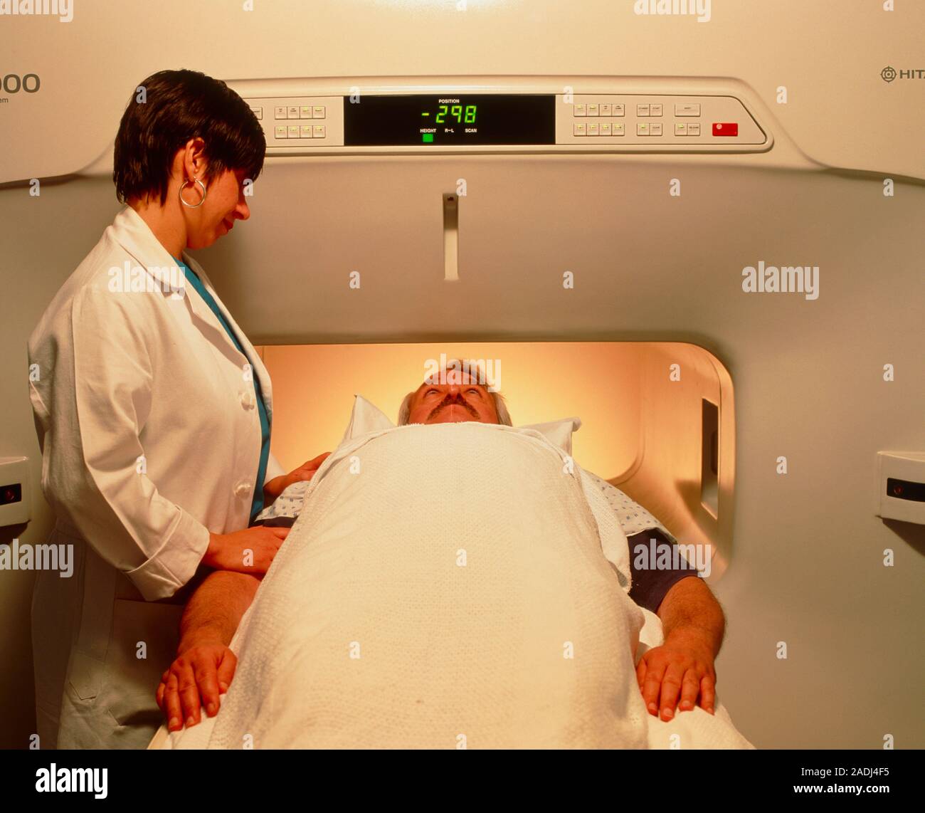 MRI scan. Lying on his back, a man enters the extra-wide chamber of an ...