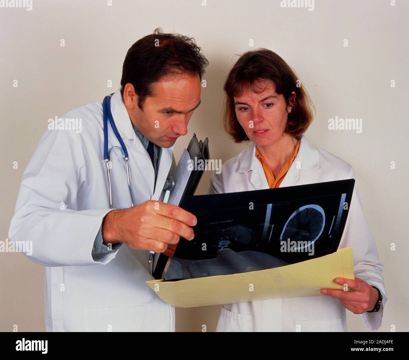MRI scan. Two doctors analyse the results of an MRI (Magnetic Resonance ...