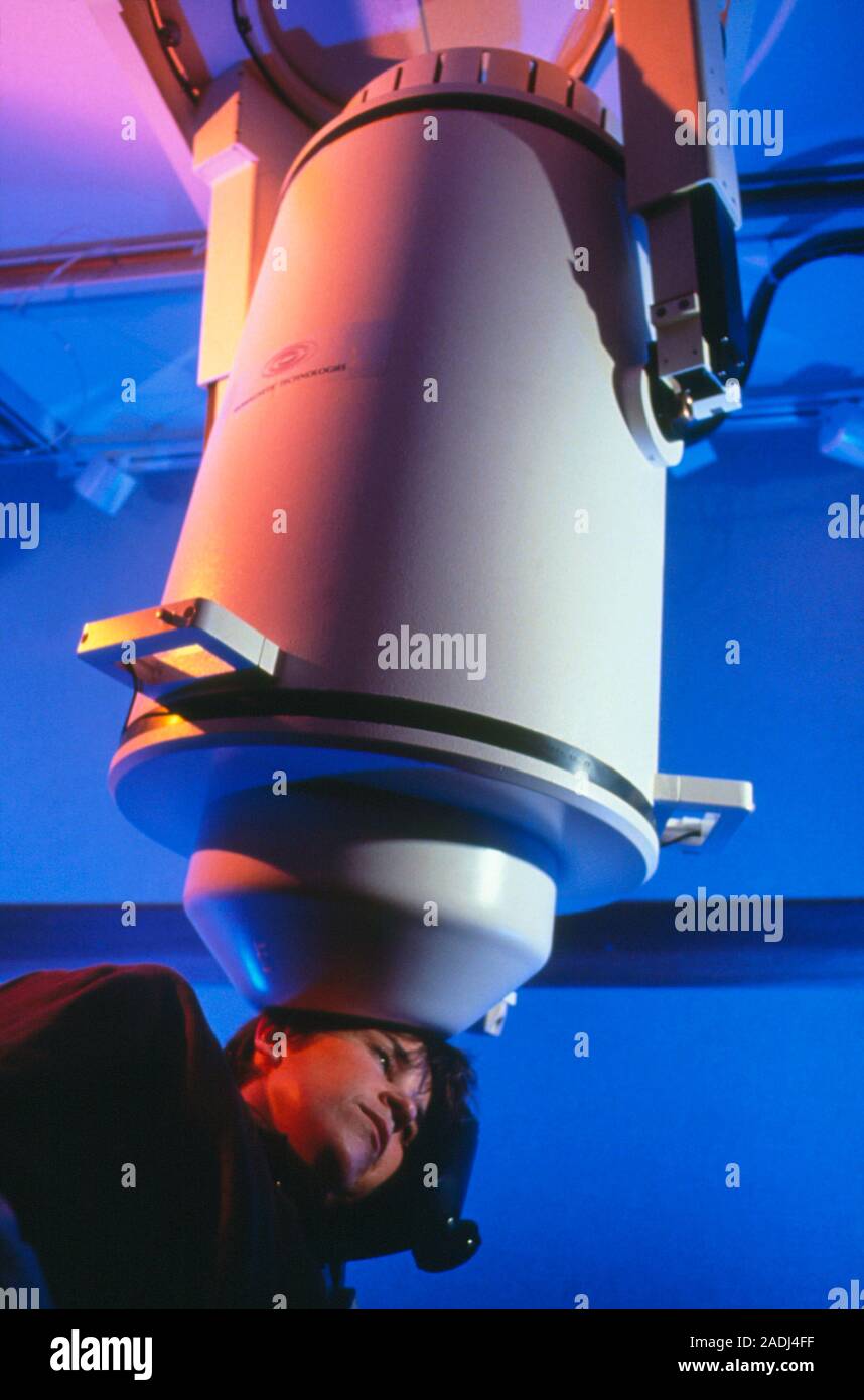 Magnetoencephalography (MEG). Woman undergoing a brain scan with a ...