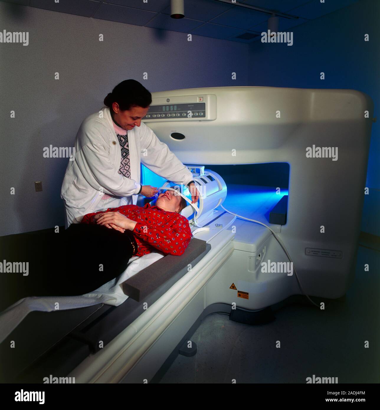 Extra-wide MRI scanner. Radio- logist prepares a woman patient for ...
