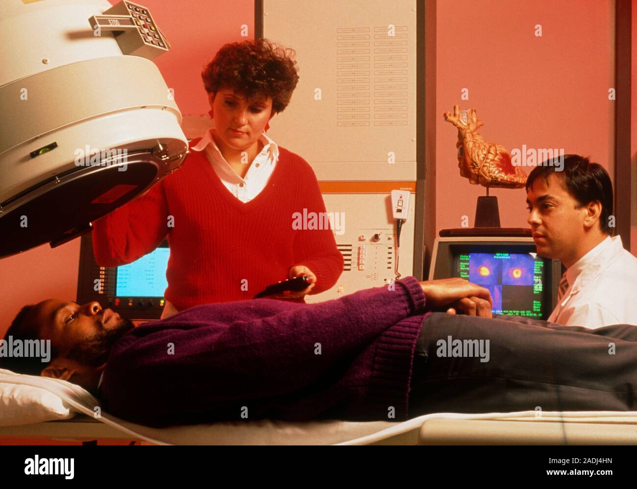 Gamma camera scan. Male patient receives a gamma scan of his neck and ...