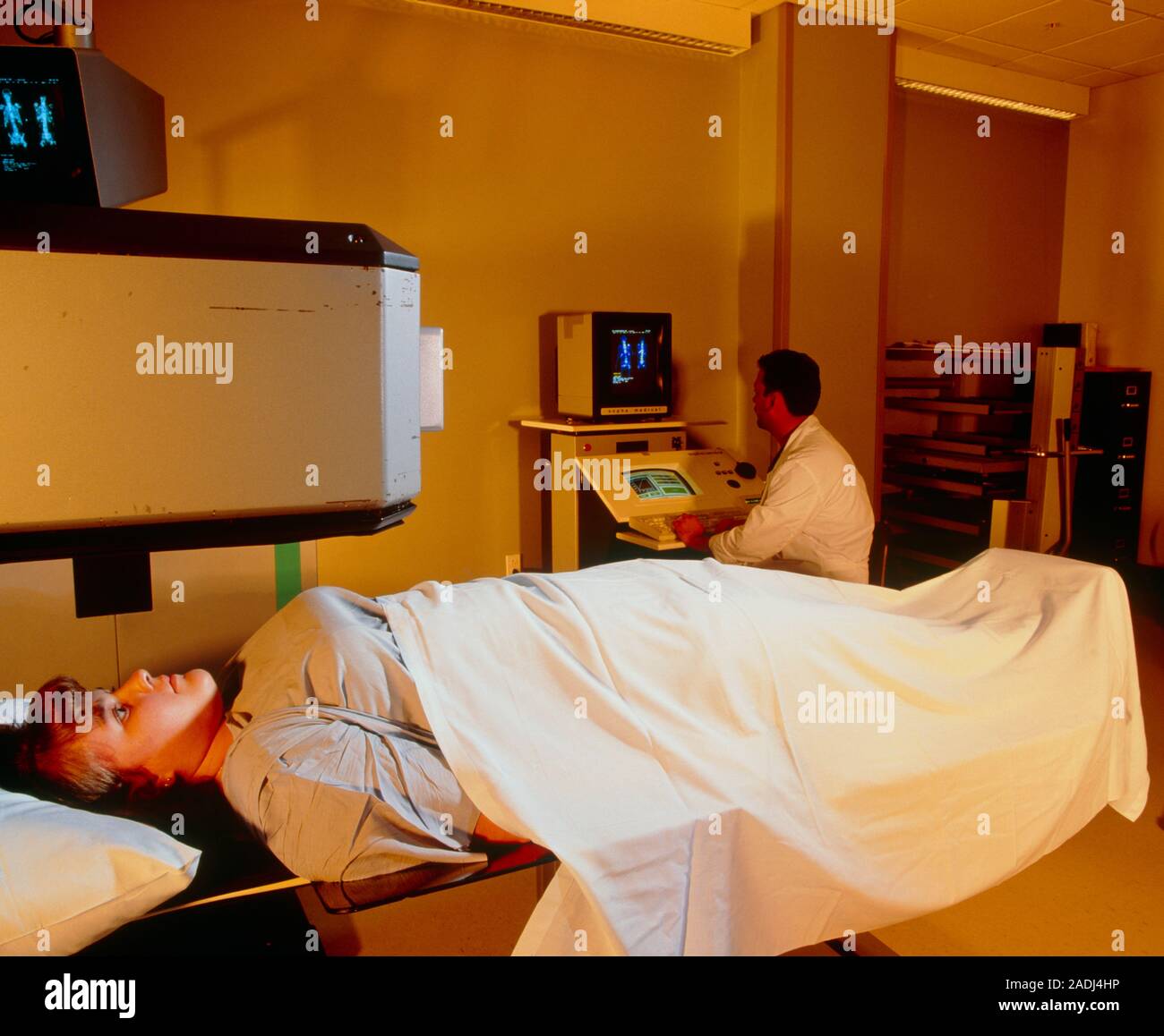Gamma camera scan. Woman patient receives a gamma camera scan ...
