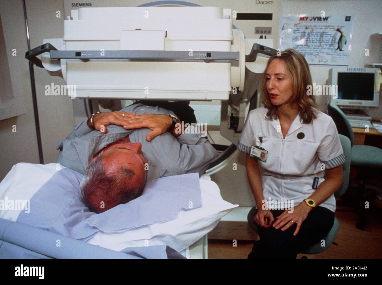 Gamma scan. Middle-aged man undergoing a gamma or radionuclide scan of ...