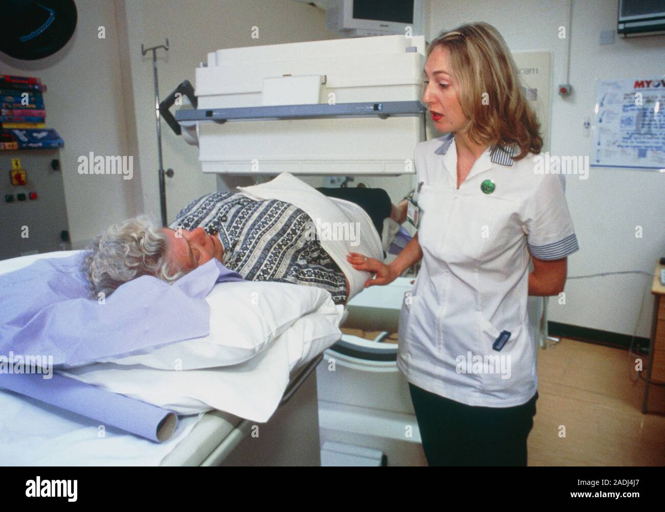 Gamma scan. Elderly woman undergoing a gamma or radionuclide scan of ...