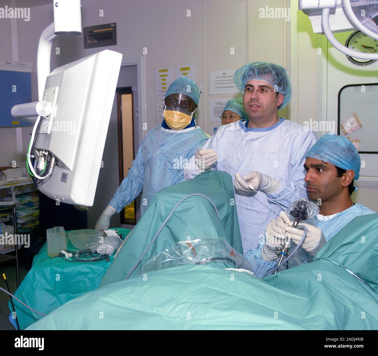 MODEL RELEASED. Endoscopy. Surgeon feeding a wire through an endoscope probe during urogenital ...