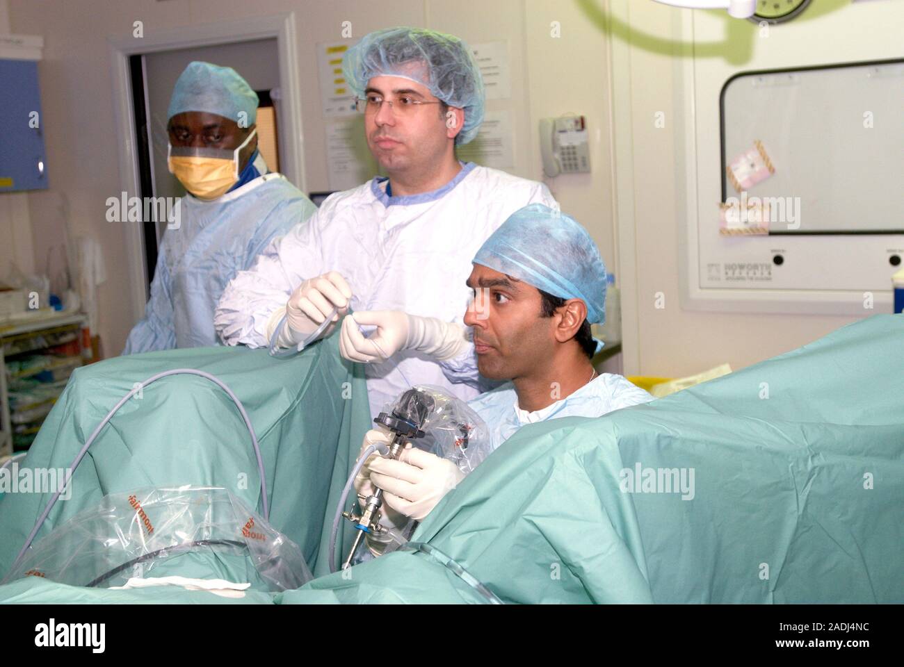 MODEL RELEASED. Endoscopy. Surgeon feeding a wire through an endoscope probe during urogenital ...