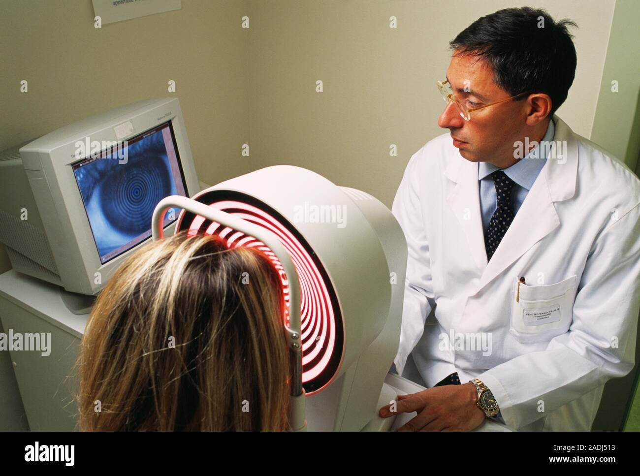 Eye examination. Patient having a corneal topography measurement made ...