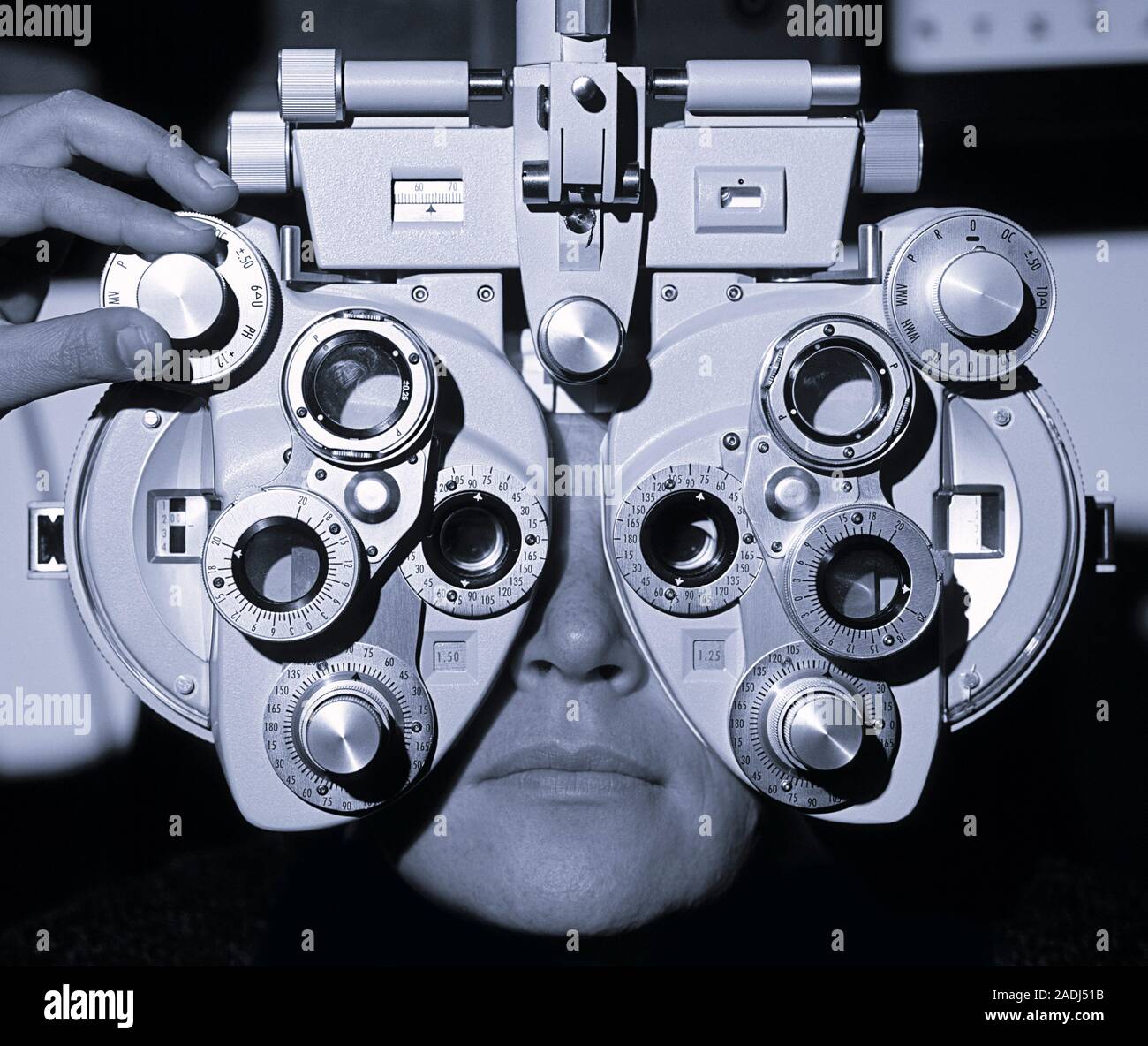 Eye examination. Man looks through a refractor during an eye ...