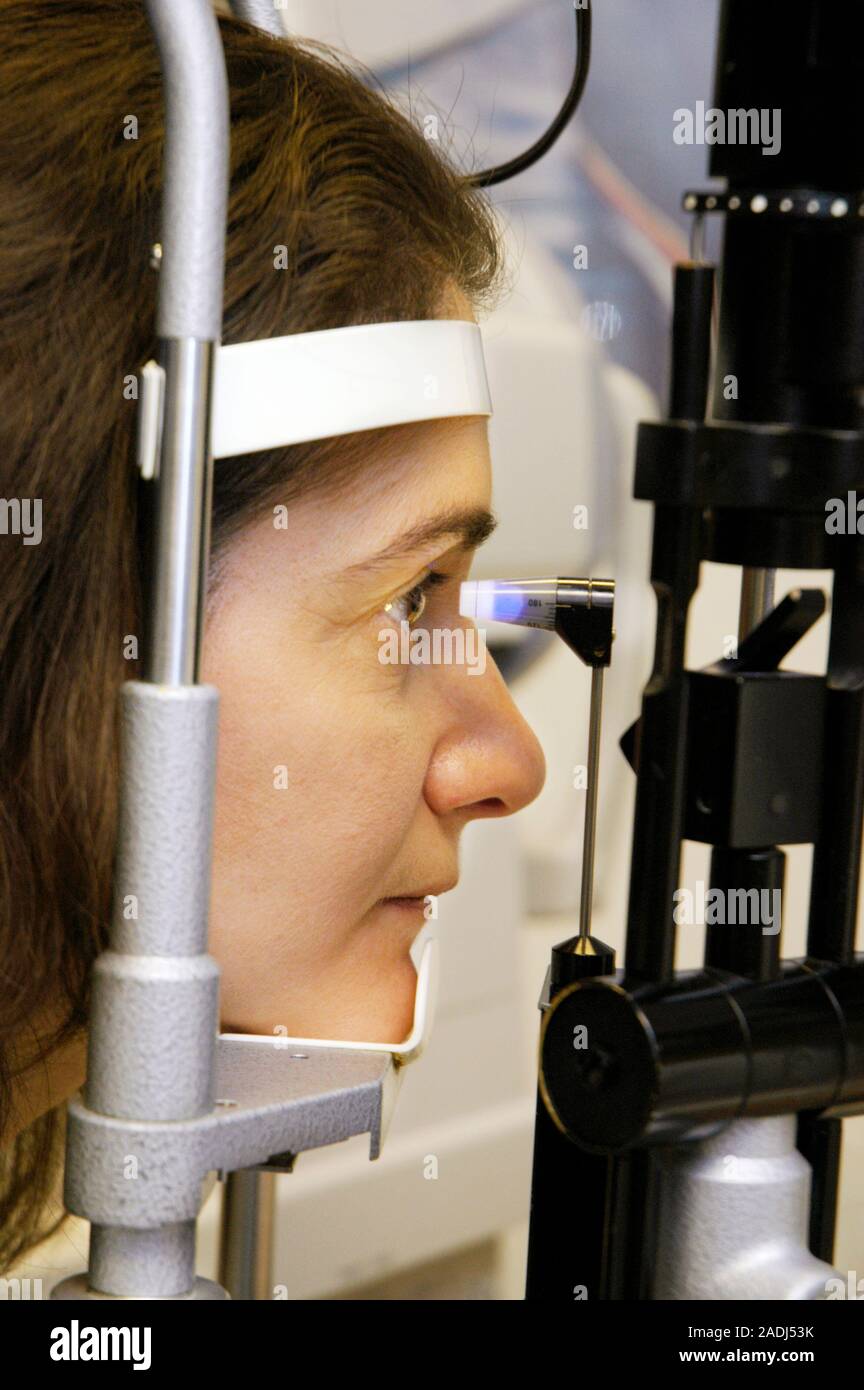 Eye examination. Patient having the pressure in her left eye examined ...