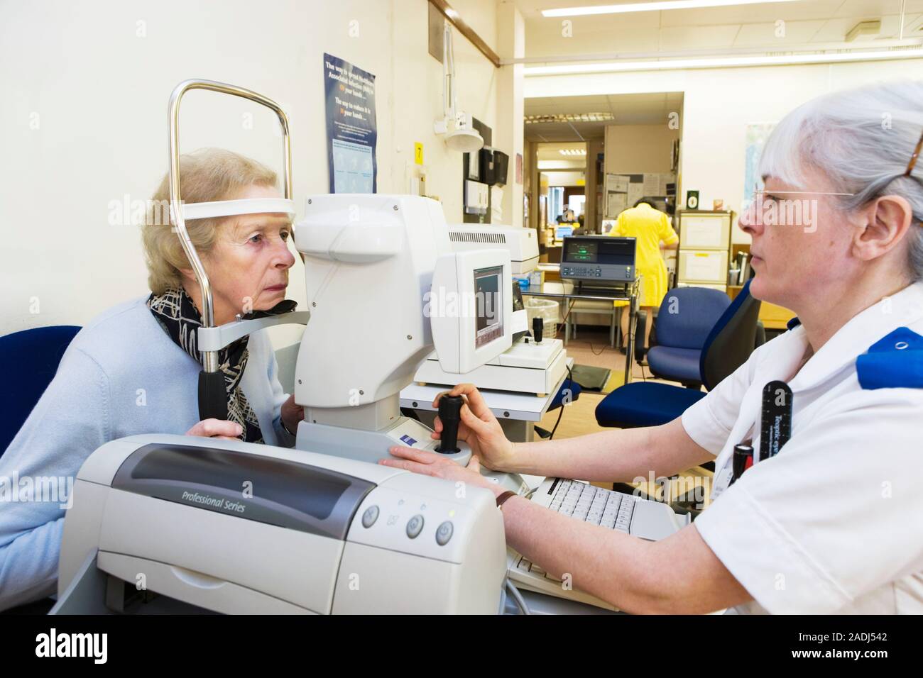 MODEL RELEASED. Eye measurements. Patient having her eyes scanned by an ...