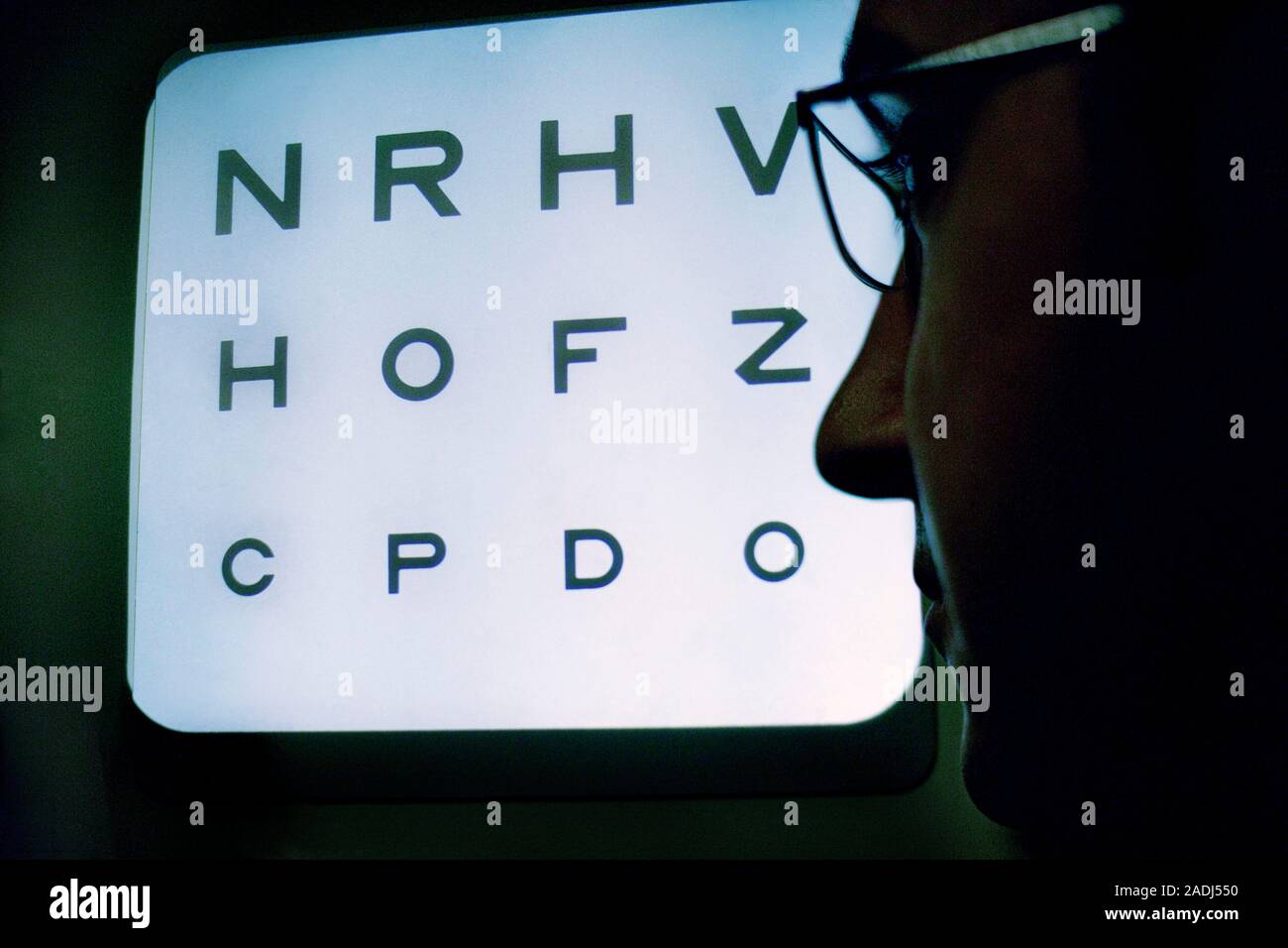 MODEL RELEASED. Eye examination. Eye chart being used to test a woman's ...