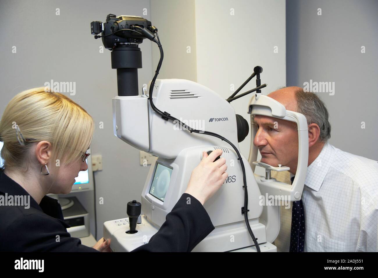 MODEL RELEASED. Eye examination. Patient having his eyes scanned by a ...