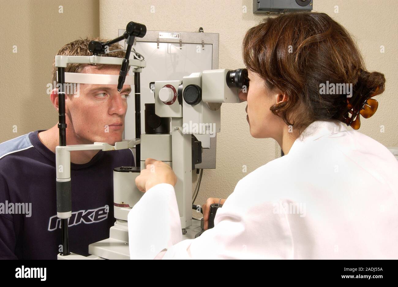 Eye examination. Ophthalmologist examining a patient's eyes using a ...