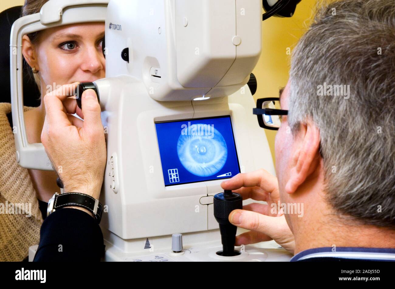 MODEL RELEASED. Eye examination. Ophthalmologist using a fundus camera ...