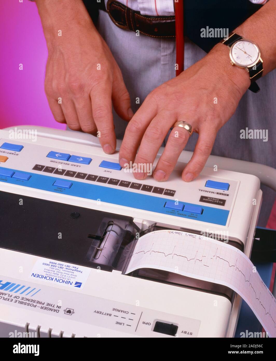 Portable ECG machine. Doctor's hands operate a portable ...