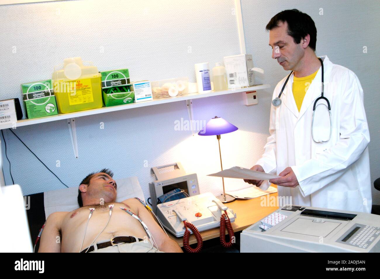 Electrocardiography. Doctor with a print-out of a 45-year-old man's ...