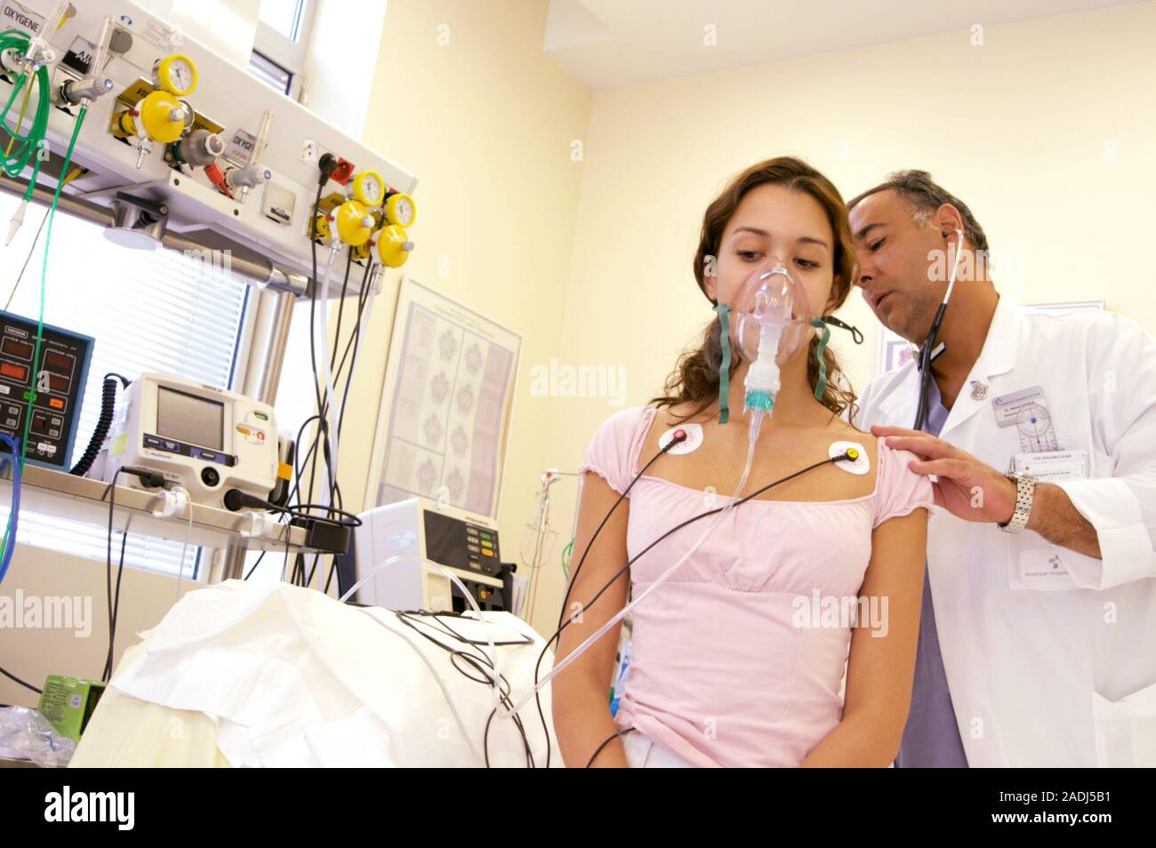 ECG test. Doctor examining a young woman's back with a stethoscope ...