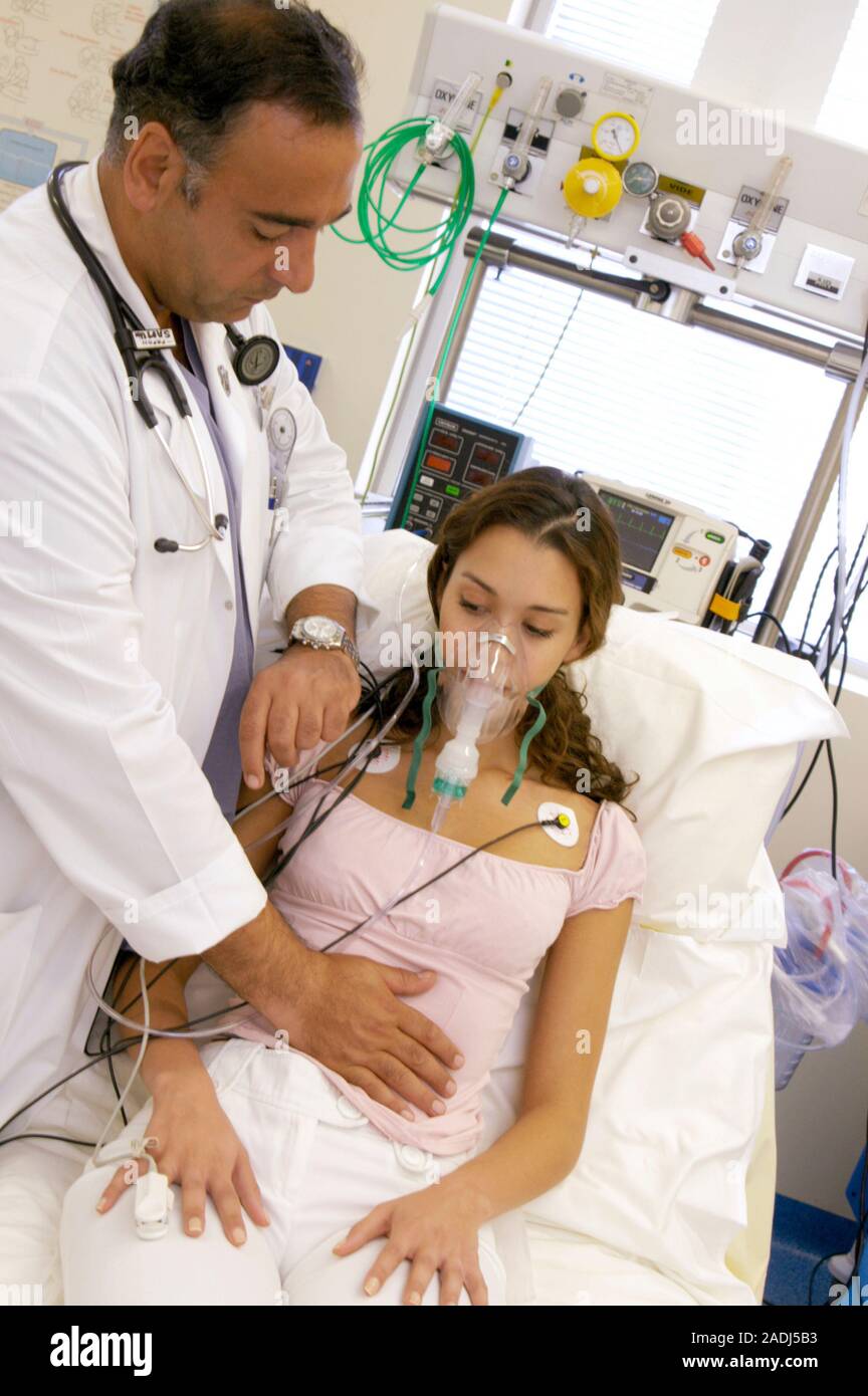 ECG test. Doctor examining a young woman while she undergoes a three ...