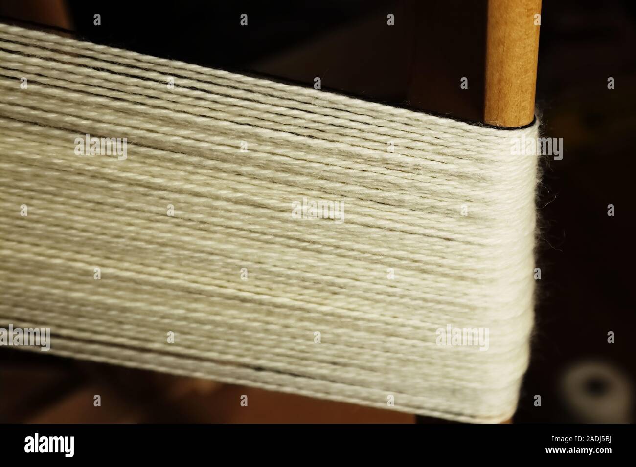 close up of white wool yarn warp on a warping mill with a black cotton ...