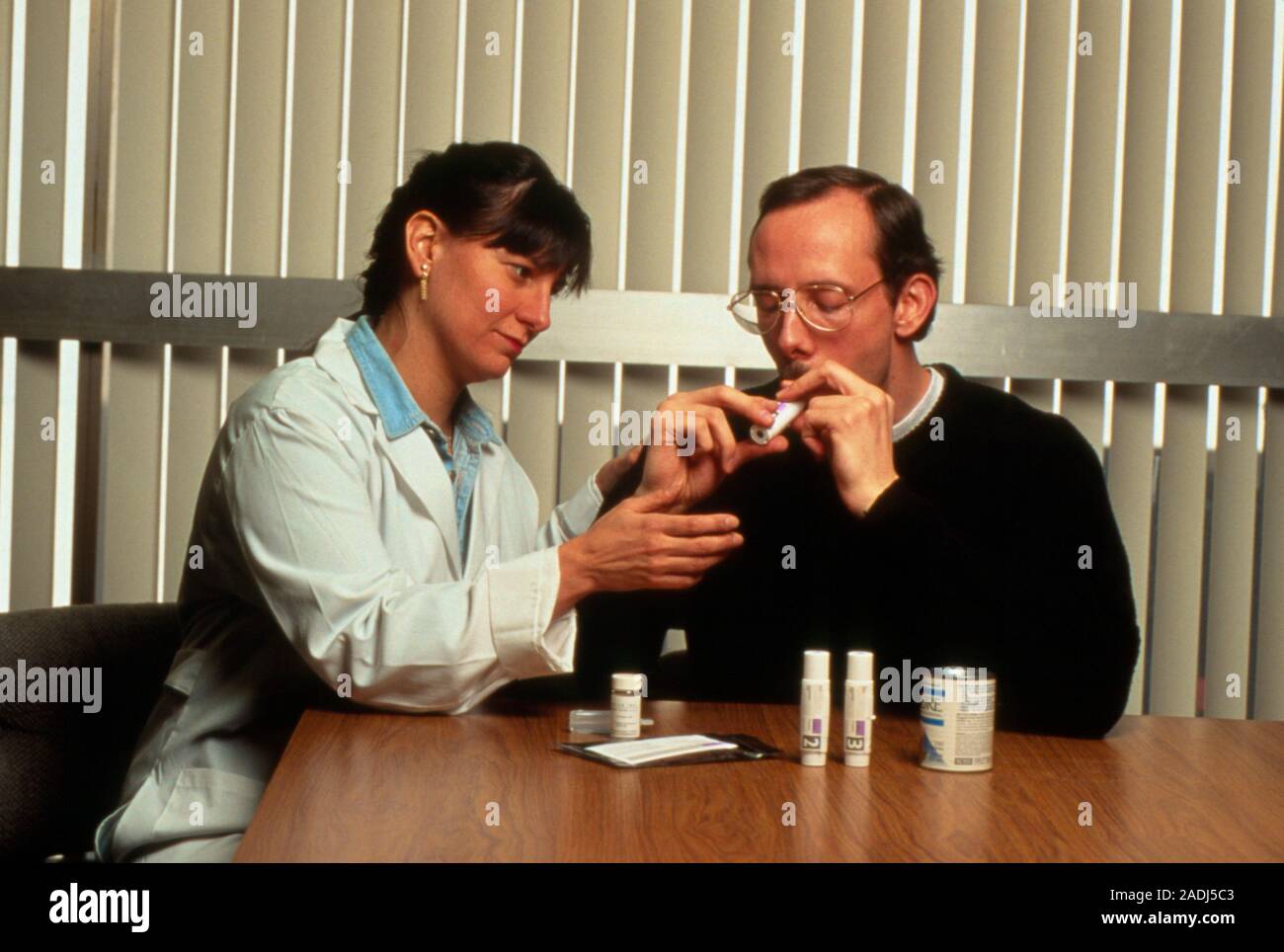Breath test for stomach ulcer. Nurse assists a male patient to exhale ...