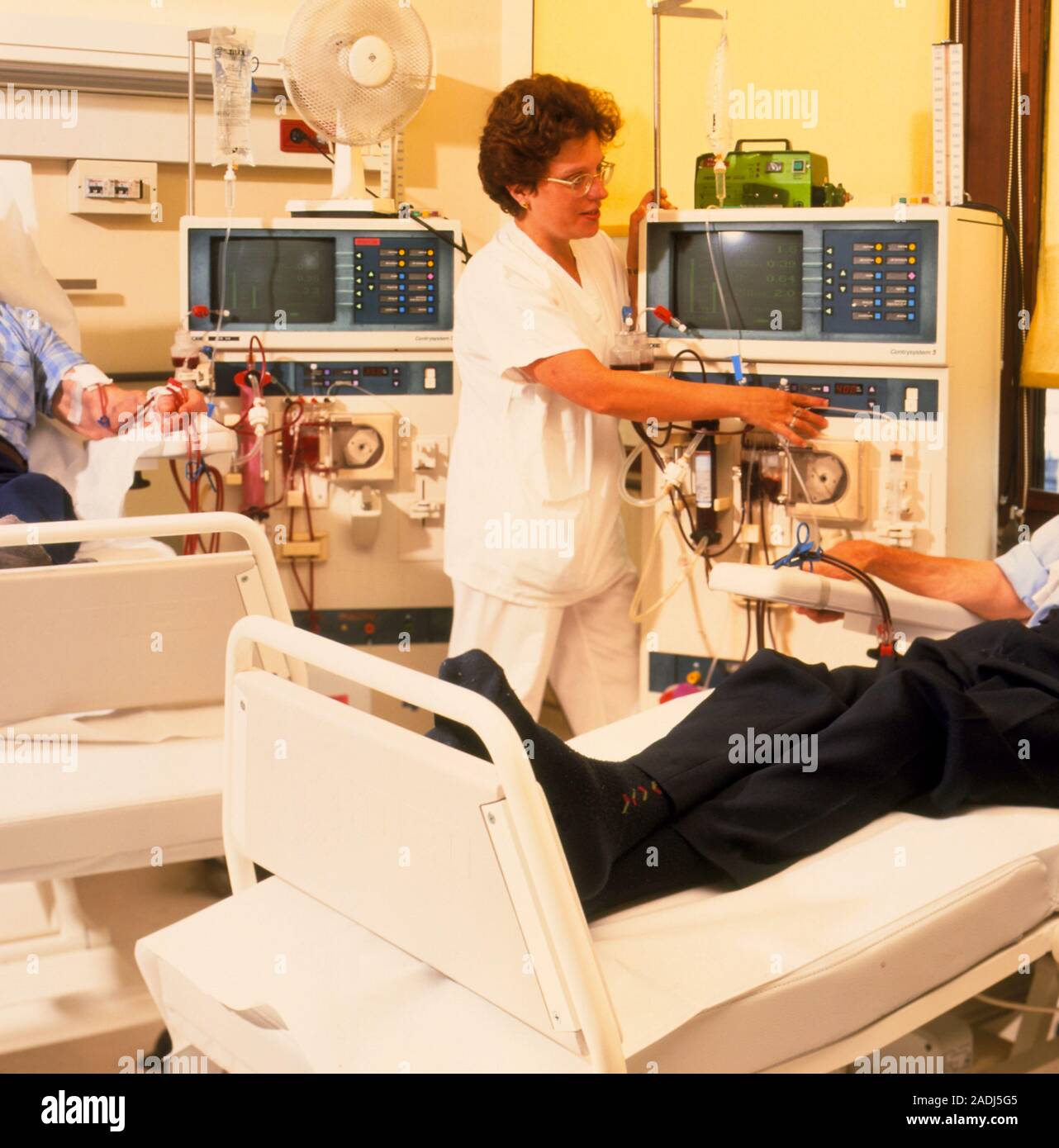 Kidney dialysis. Nurse assists two men during the procedure of kidney ...