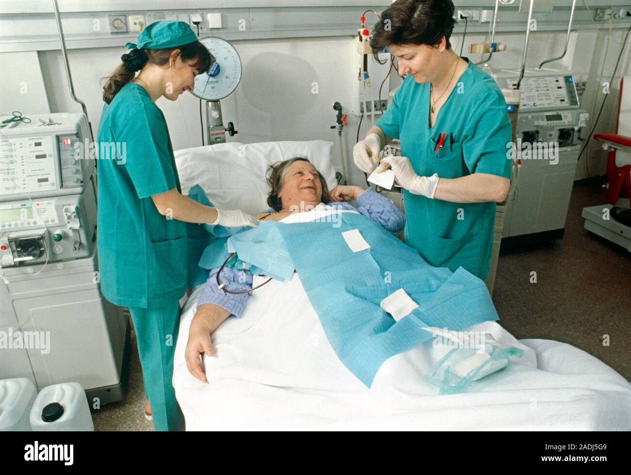 Kidney dialysis. Medical staff prepare a woman for kidney dialysis ...