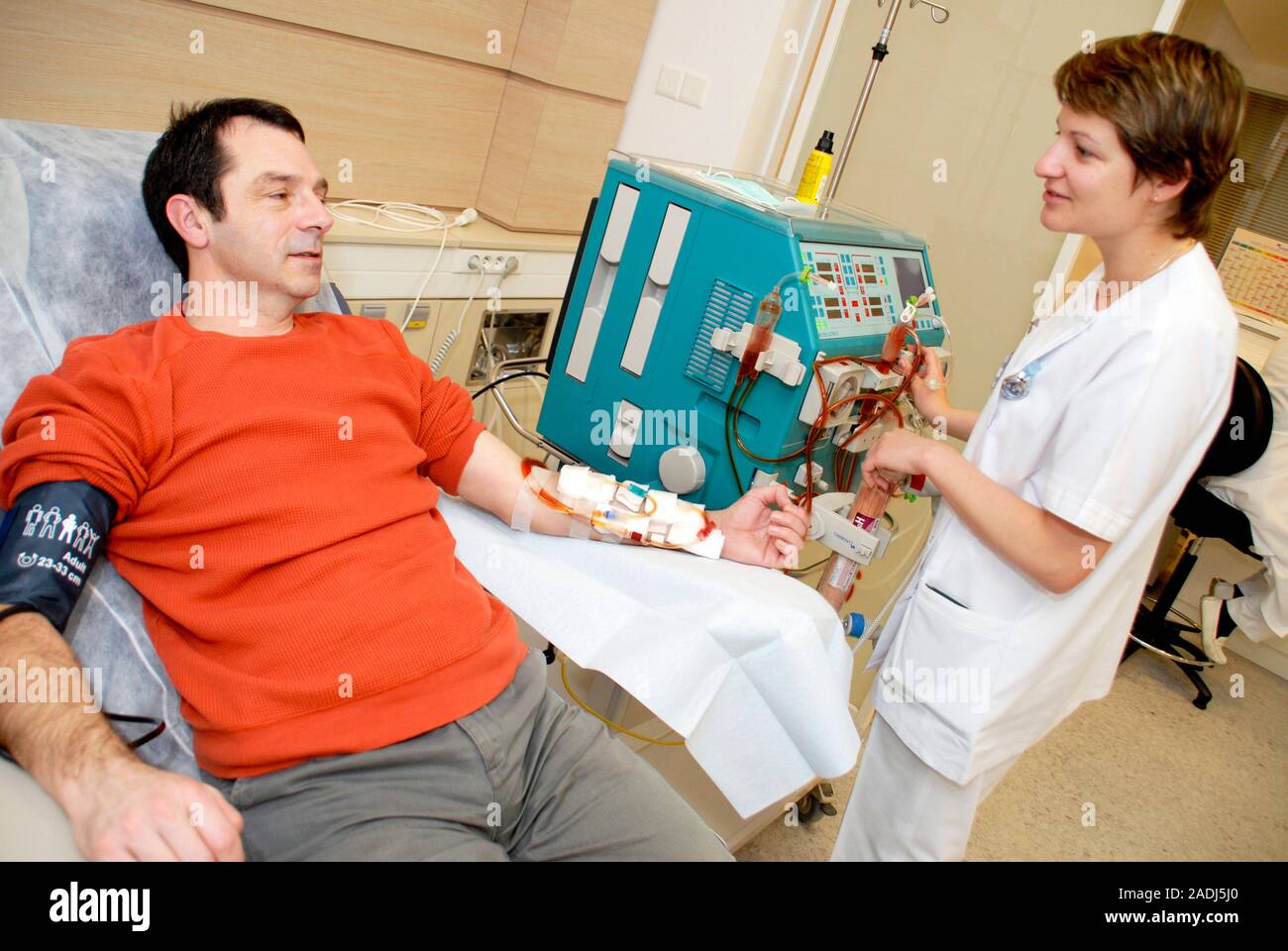 Dialysis unit. Nurse checking on a patient in a dialysis treatment unit ...