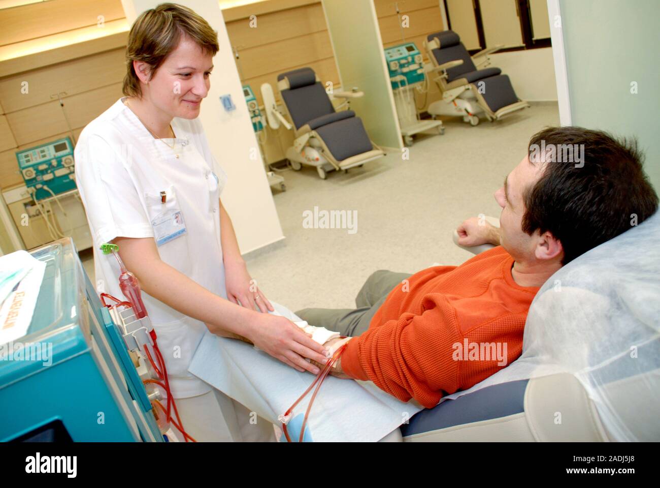 Dialysis unit. Nurse checking on a patient in a dialysis treatment unit ...