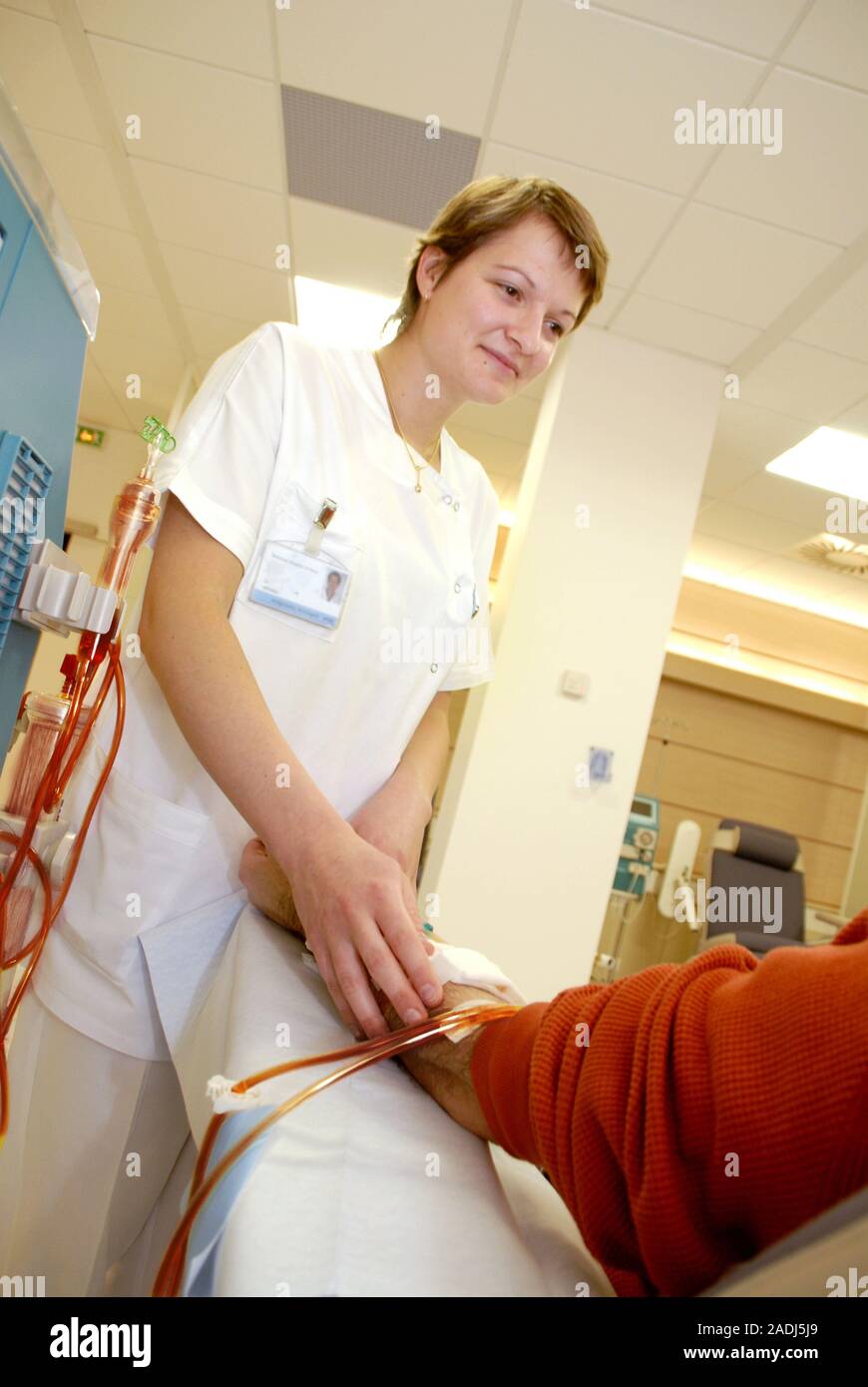 Dialysis unit. Nurse checking on a patient in a dialysis treatment unit ...