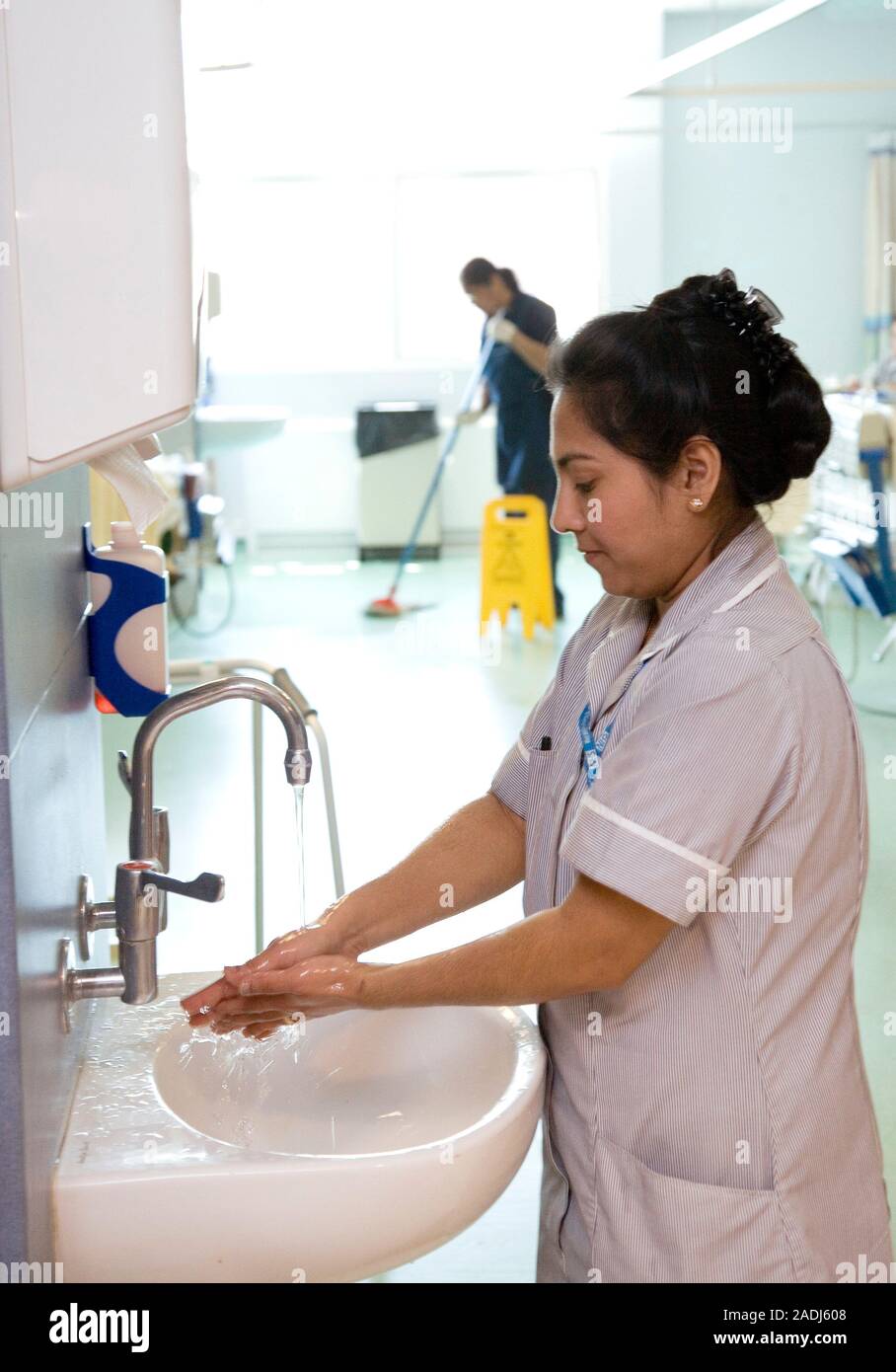 MODEL RELEASED. Hospital hygiene. Nurse washing her hands and cleaning ...