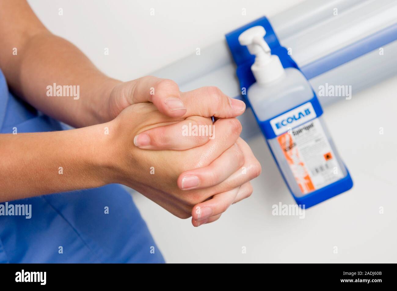MODEL RELEASED. Hospital hygiene. Nurse cleaning her hands with alcohol ...