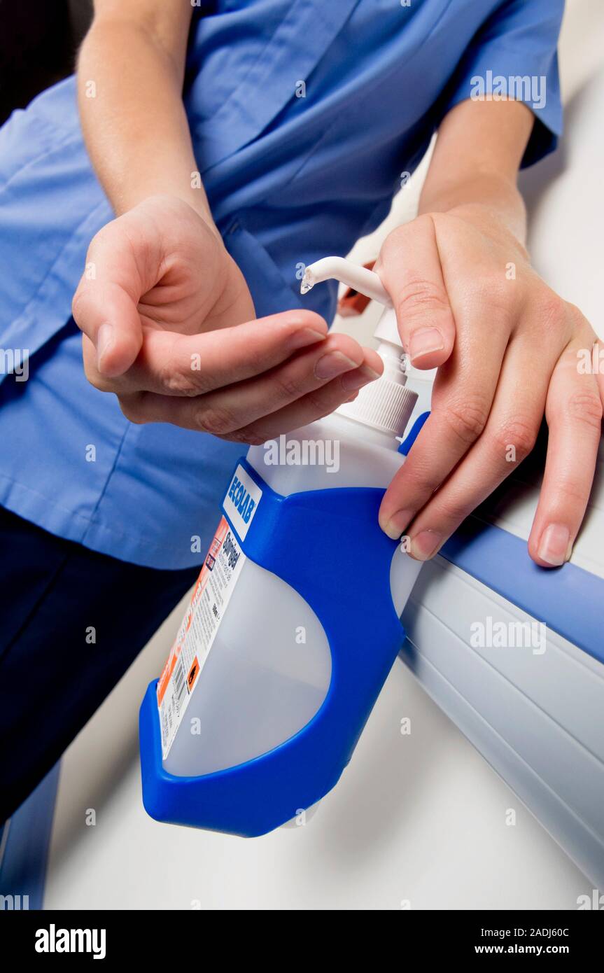 MODEL RELEASED. Hospital hygiene. Nurse cleaning her hands with alcohol ...