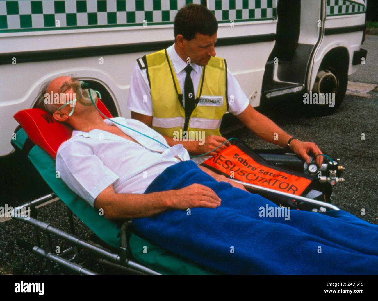 Patient being given oxygen by an ambulanceman after a roadside accident ...