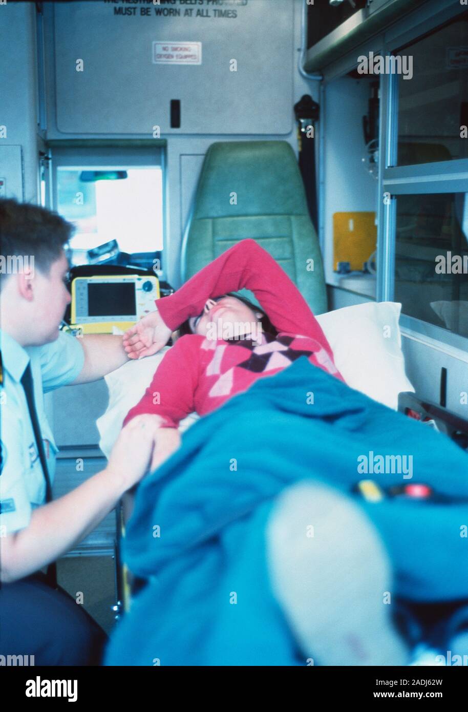 Ambulance treatment. Paramedic comforting a patient in an ambulance ...