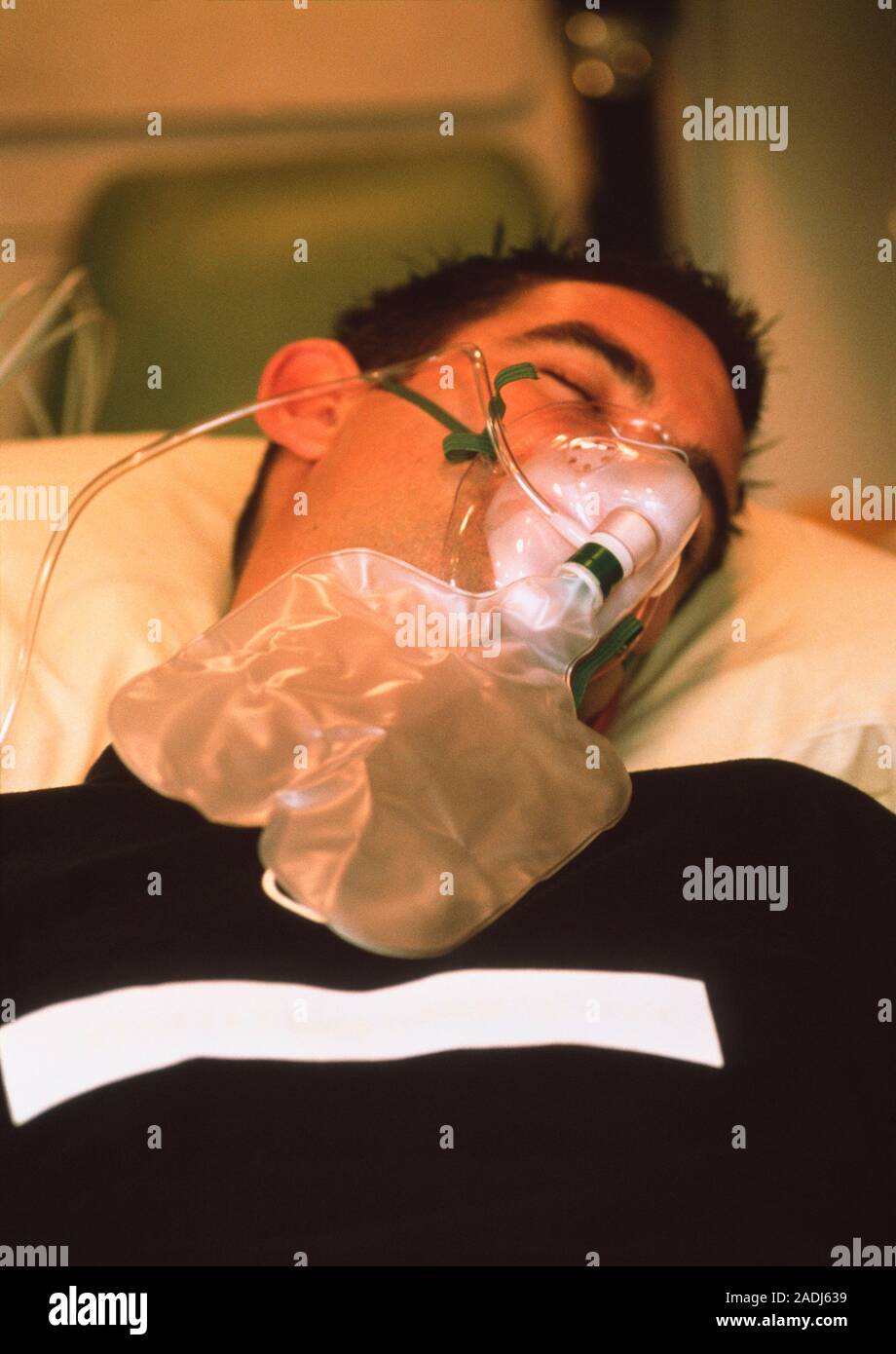 Ambulance treatment. Patient wearing a face mask in an ambulance. The ...