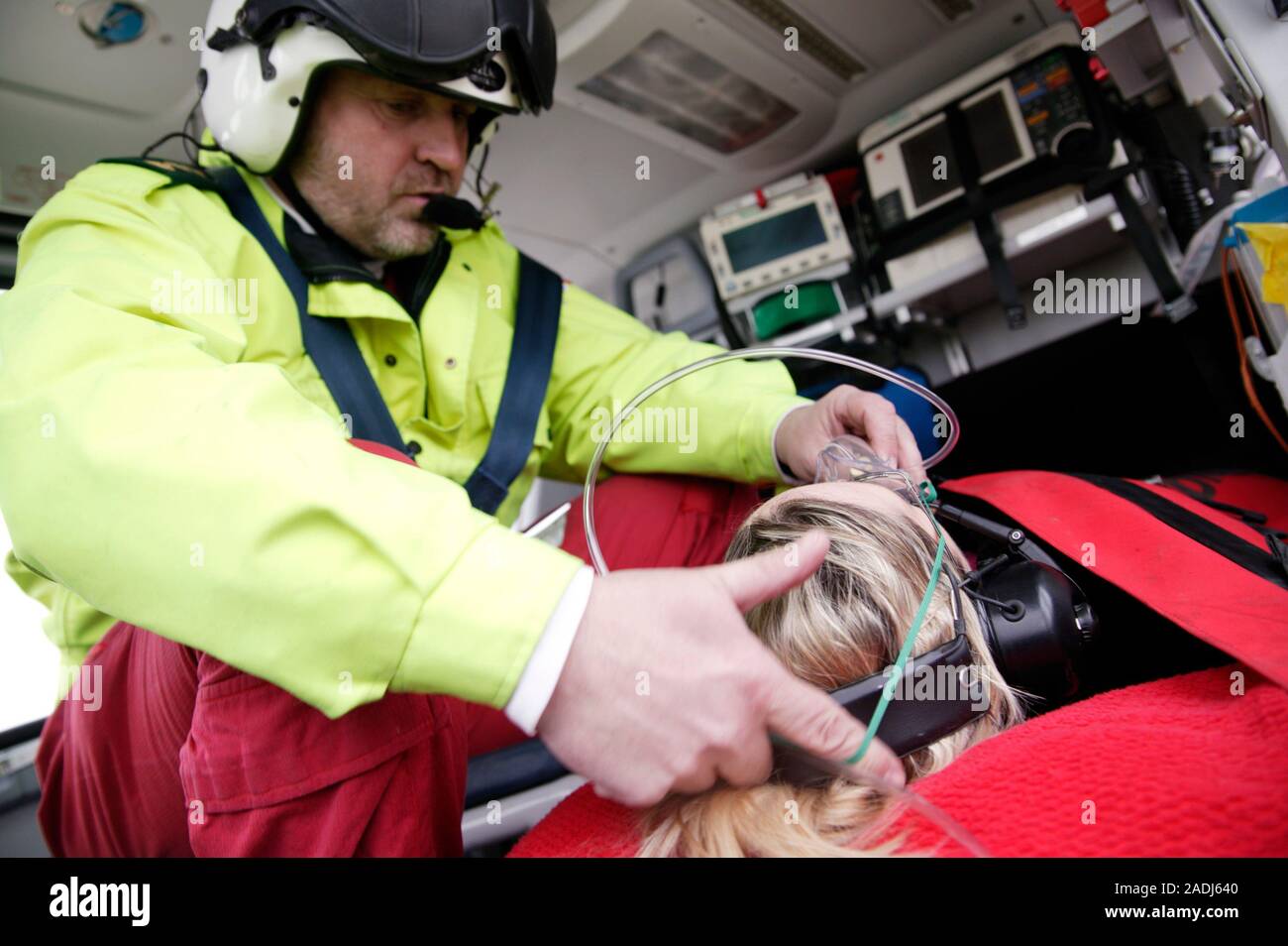 Air ambulance treatment. Paramedic placing an oxygen mask on a patient ...