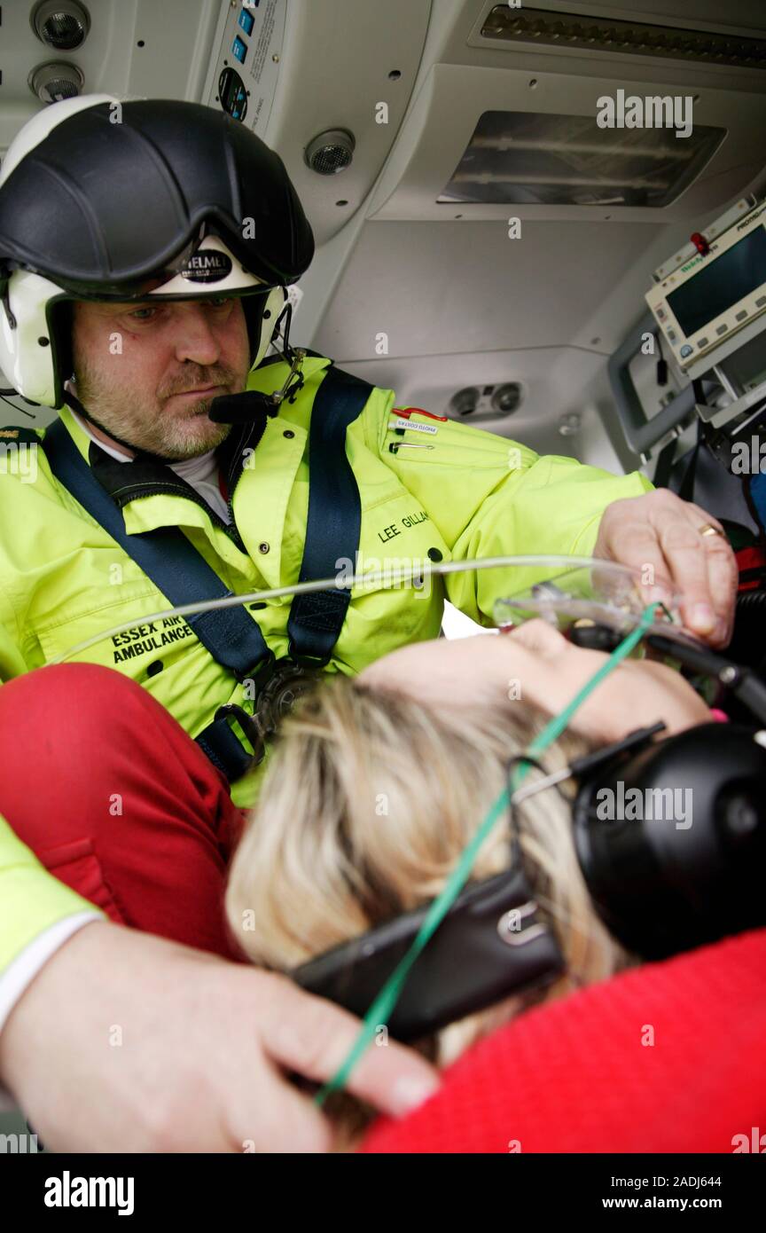 Air ambulance treatment. Paramedic placing an oxygen mask on a patient ...