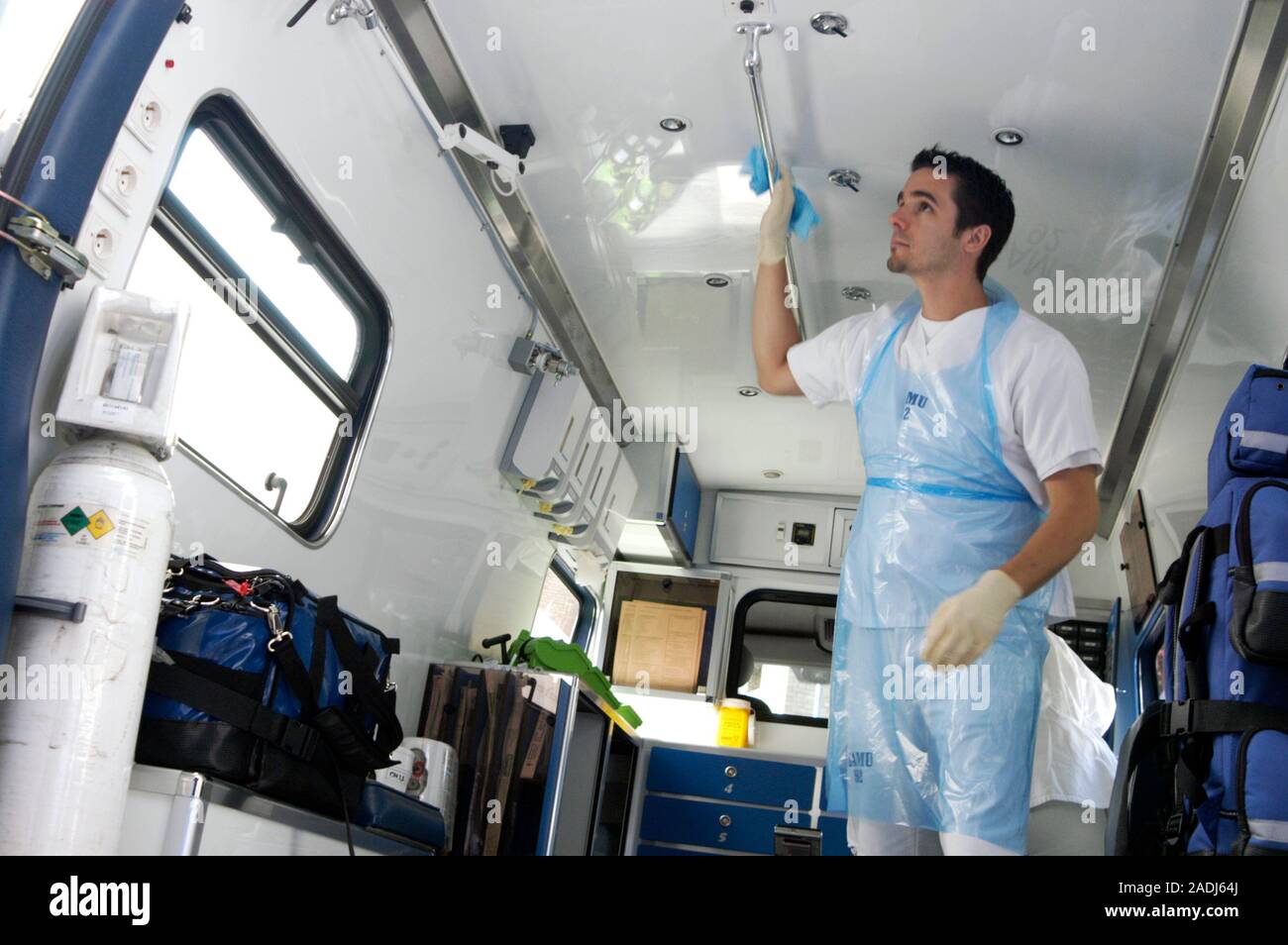Ambulance hygiene. French paramedic disinfecting an ambulance between ...