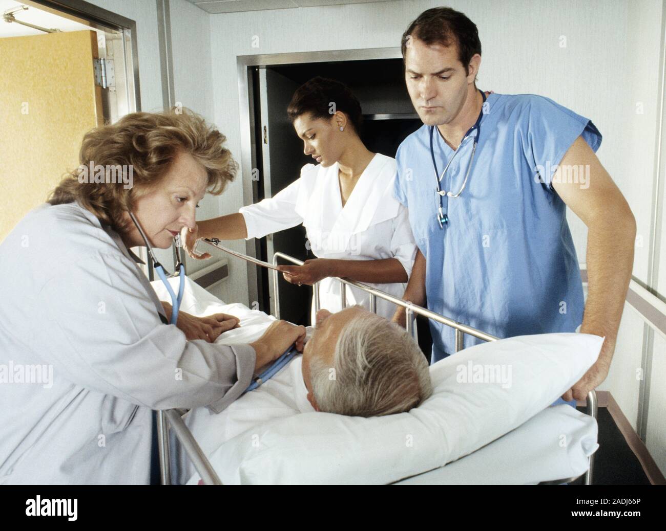 Emergency treatment. Elderly male patient on a stretcher is given ...