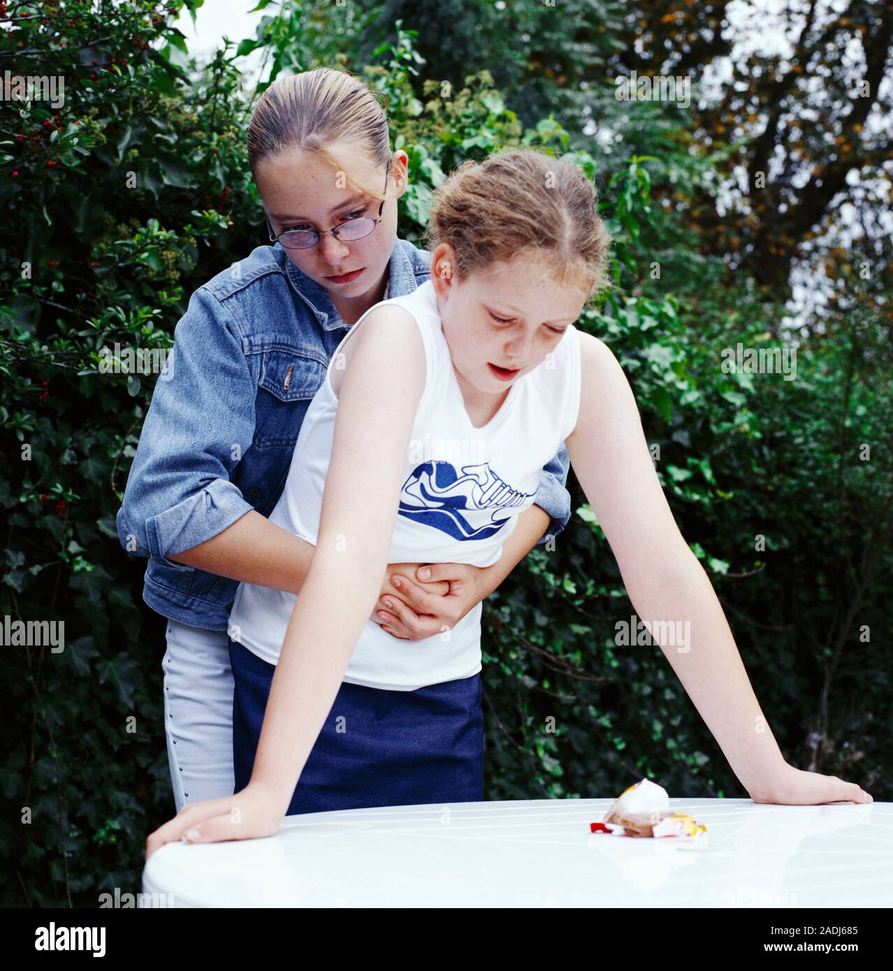 Heimlich manoeuvre. Choking girl having the Heimlich manoeuvre ...