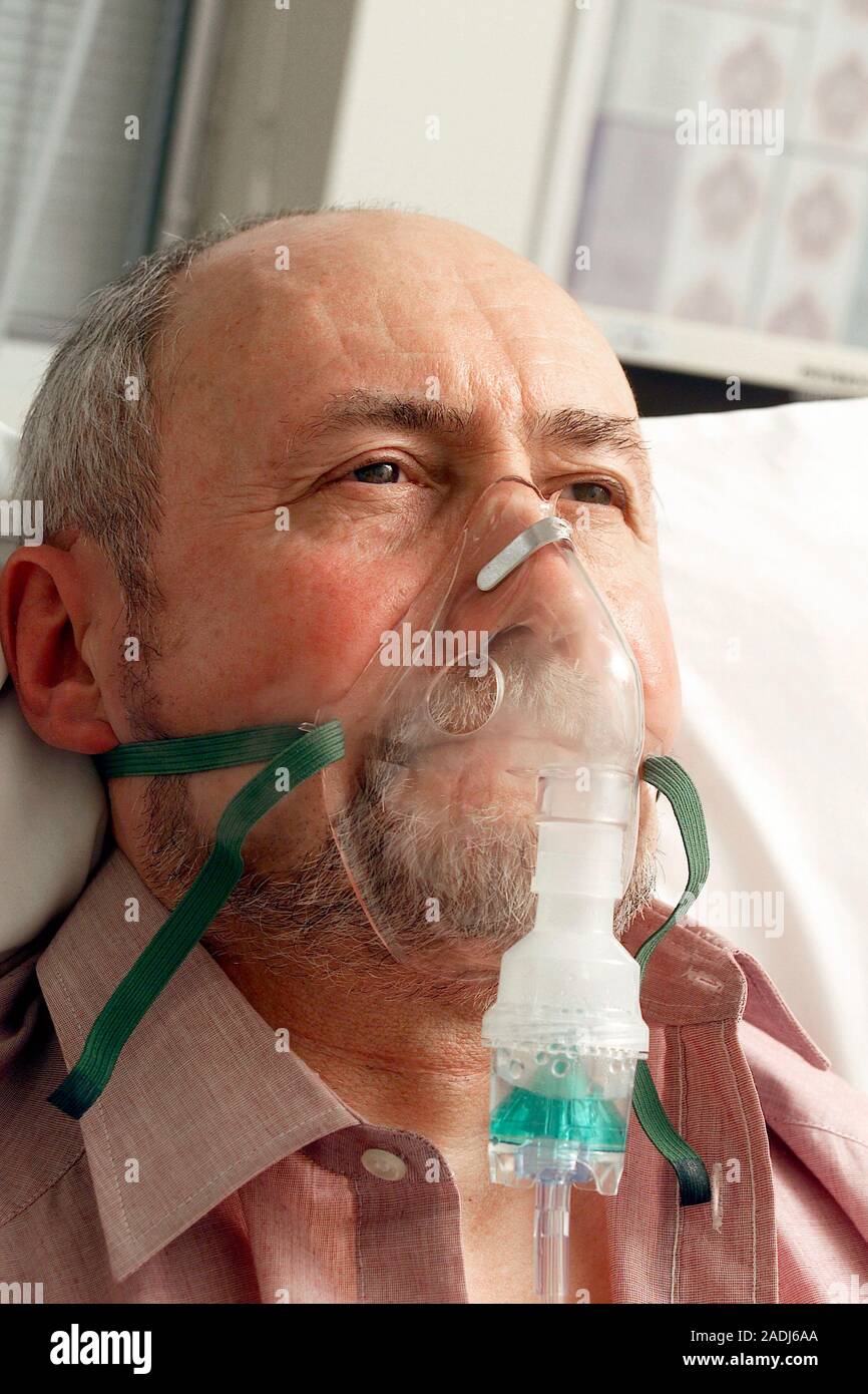 Emergency treatment. Elderly man wearing an oxygen mask for the ...