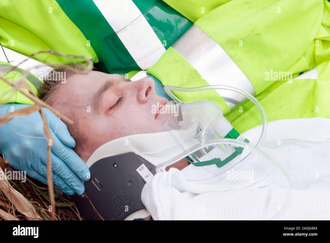 Emergency treatment. Paramedic treating a man with a suspected neck ...