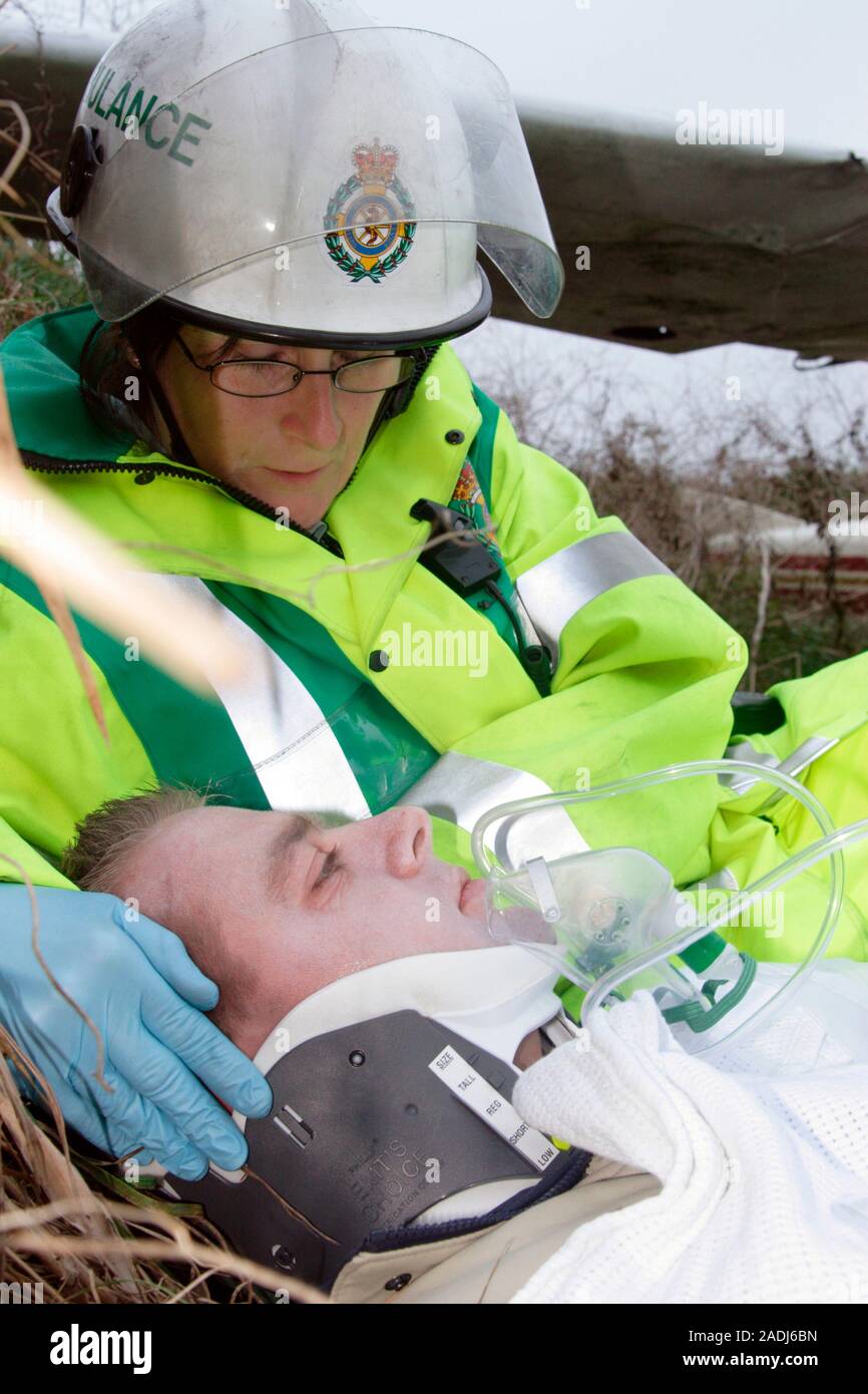 Emergency treatment. Paramedic treating a man with a suspected neck ...