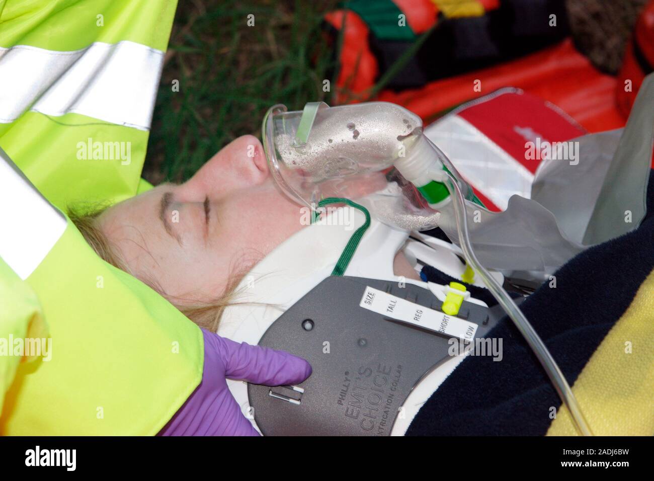 Emergency treatment. Paramedic treating a woman with a suspected neck ...