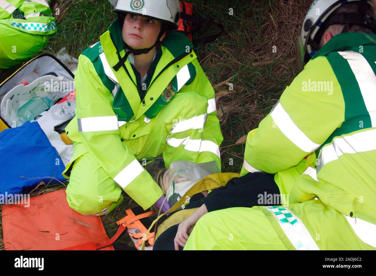 Emergency treatment. Paramedics treating a woman with a suspected neck ...