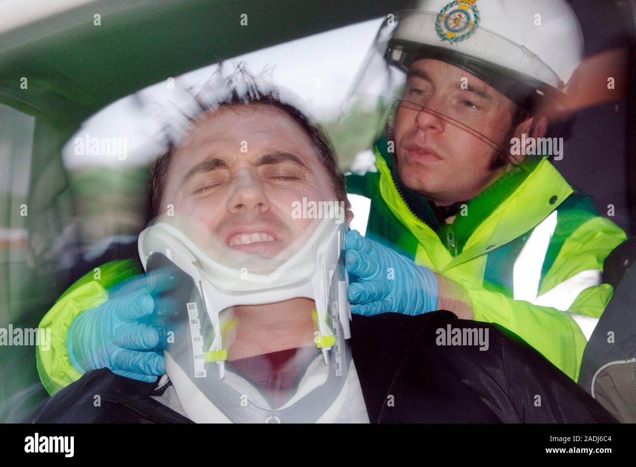 Emergency treatment. Paramedic treating a man with a suspected neck ...