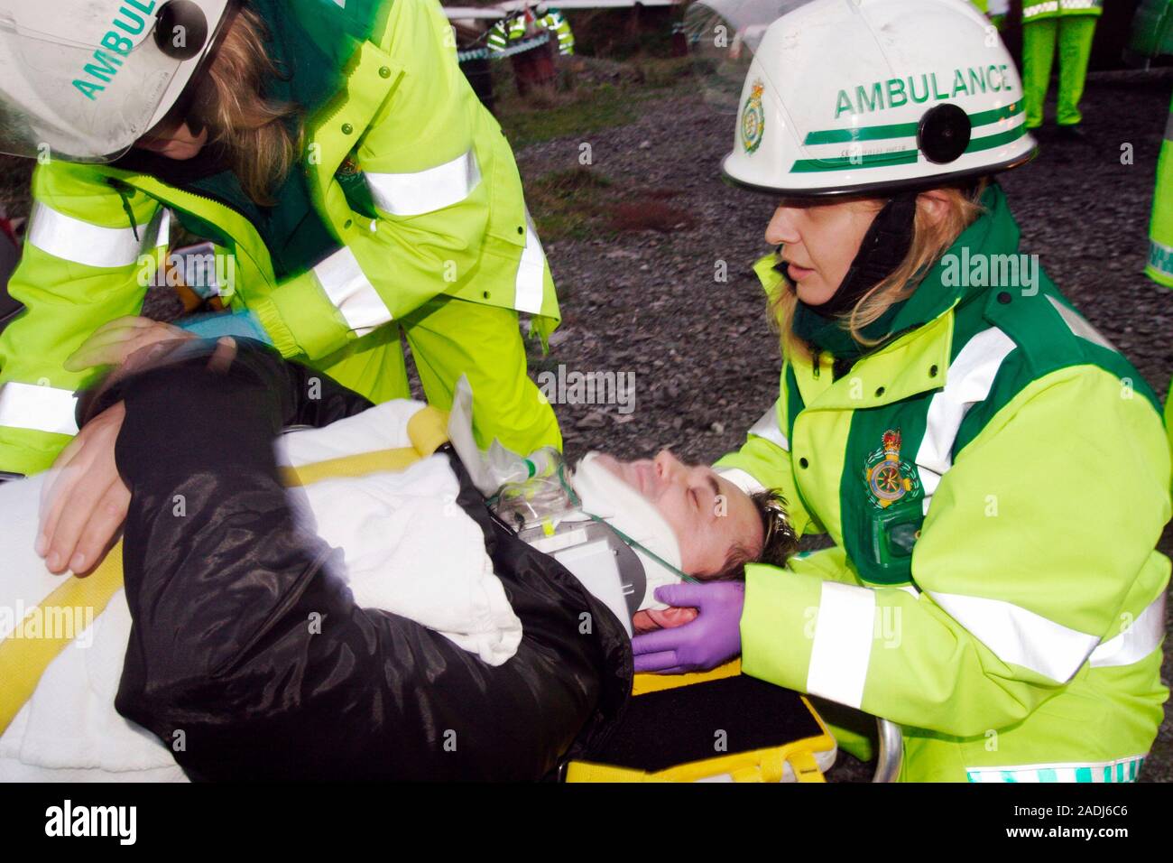 Emergency treatment. Paramedics treating a man with a suspected neck ...
