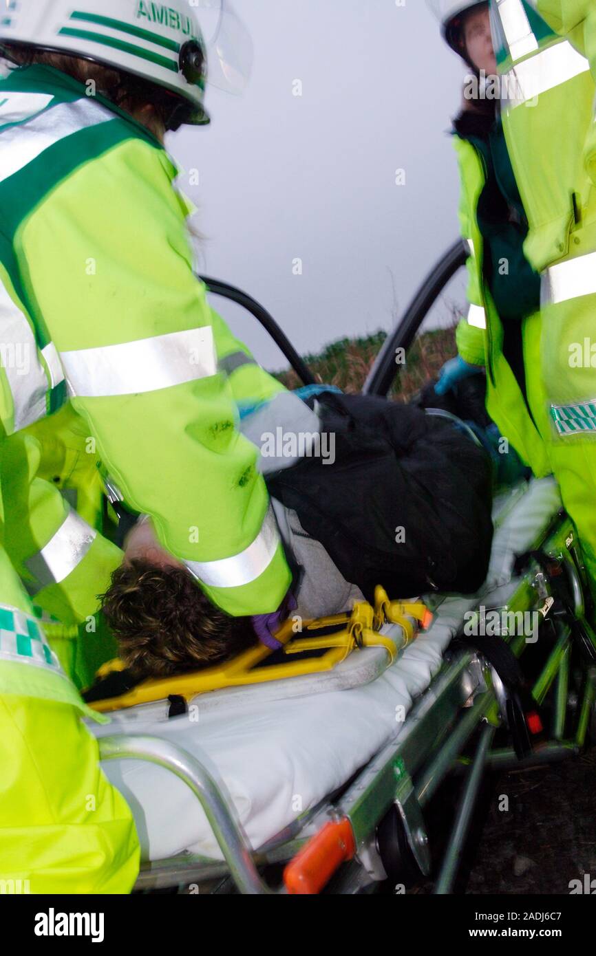 Emergency treatment. Paramedics treating a man with a suspected neck ...