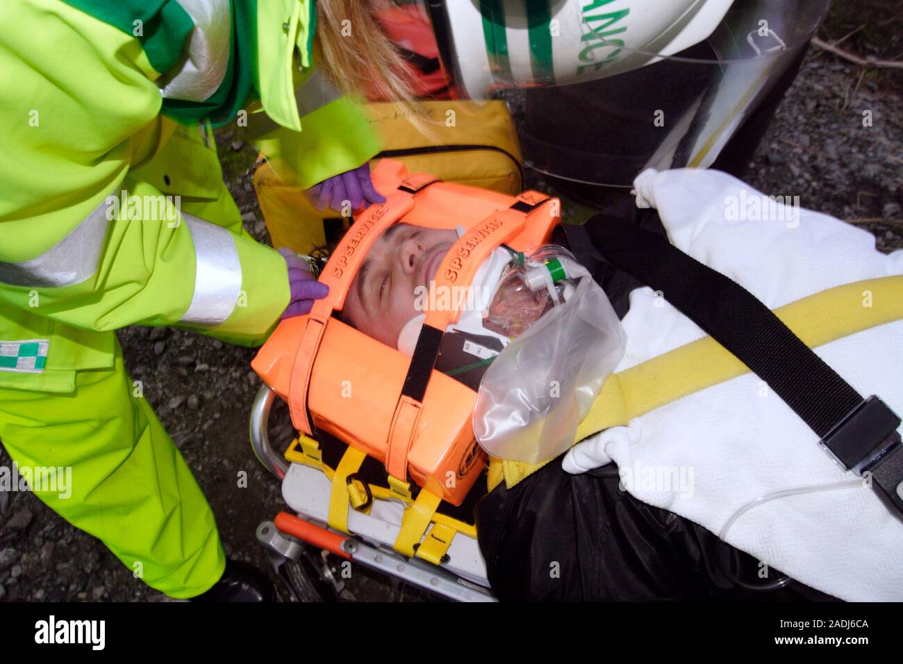 Emergency treatment. Paramedic treating a man with a suspected neck ...