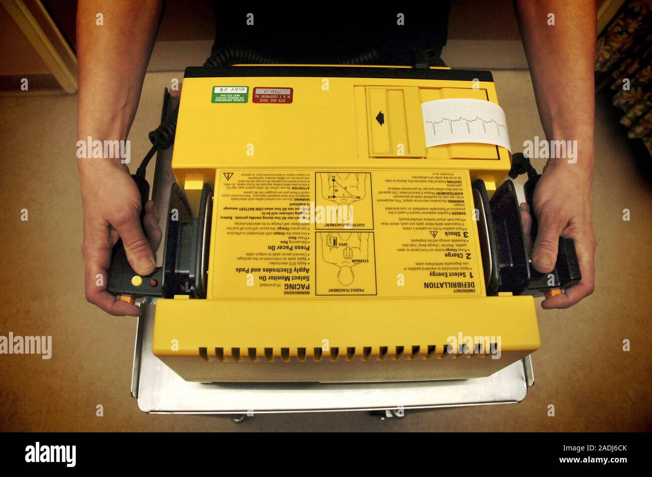 Defibrillator. Doctor holding the pads of a defibrillator, while they ...